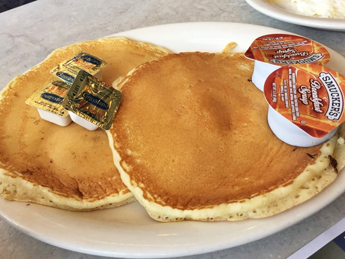 Golden-brown pancake perfection that would make Leslie Knope weep with joy. Two butter pats standing by, ready for their maple syrup bath.