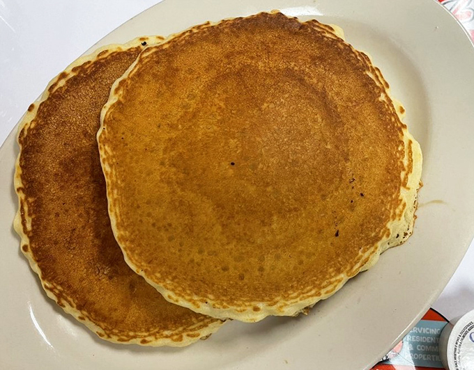 Pancakes so fluffy they practically need their own ZIP code, crowned with a melting pat of butter that creates delicious golden rivulets.