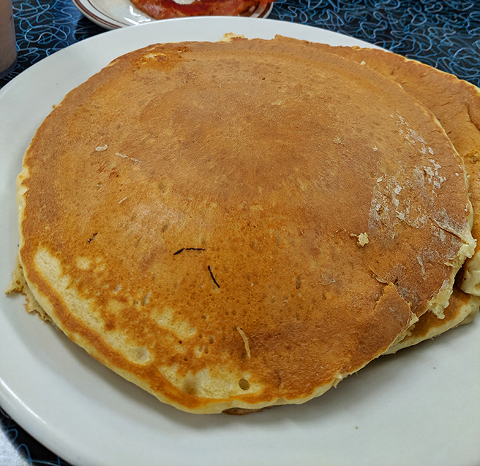 This pancake isn't just big&mdash;it's the size of a frisbee with the golden-brown perfection that makes you wonder if they hired the sun as their griddle master.