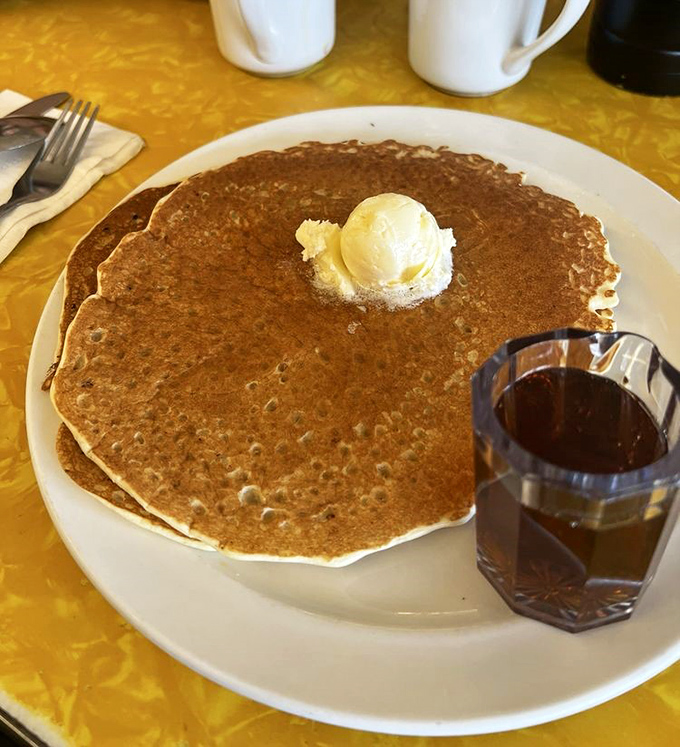 The pancake that launched a thousand road trips. Golden, perfectly round, with a pat of butter slowly melting into its fluffy embrace.
