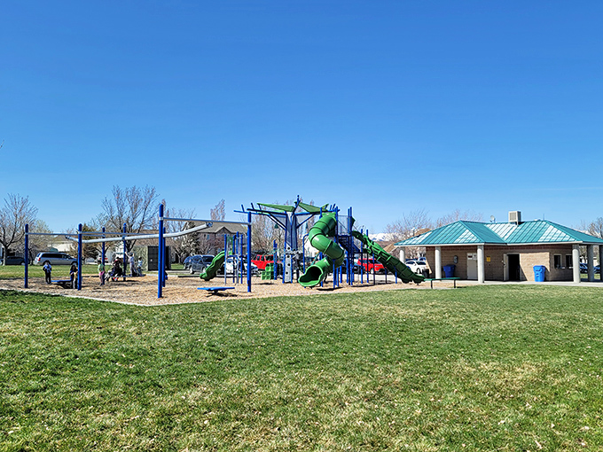 Modern playground equipment under pristine blue skies &ndash; where children burn energy and parents secretly wish they could join the fun.