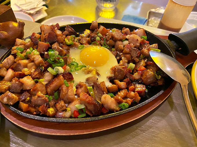 The legendary pork sisig arrives with theatrical sizzle, crispy bits mingling with tender morsels beneath a perfect egg&mdash;a flavor symphony that demands an encore.