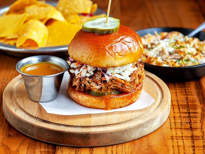 Meet the sandwich that launched a thousand food pilgrimages. Slow-smoked pork piled high with slaw and pickles on a glossy brioche bun.