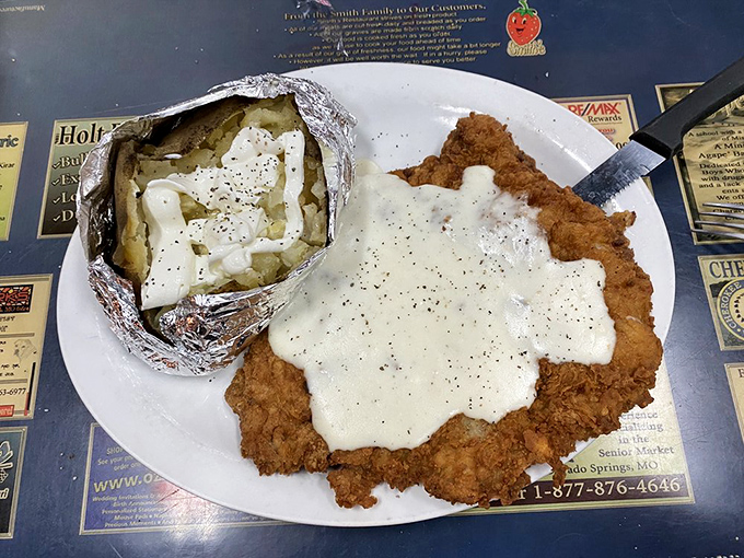 Behold the legendary pork tenderloin in all its golden-fried glory, accompanied by a loaded baked potato that's practically begging to be devoured.