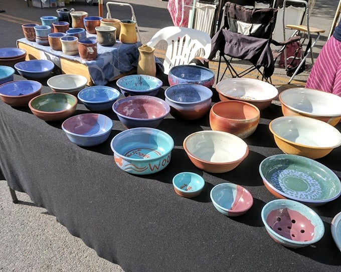 A rainbow of handcrafted ceramics catches the morning light, each bowl holding stories of clay transformed by local hands and fire.