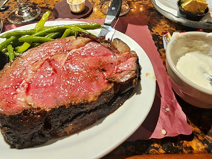 Behold the prime rib in its natural habitat – perfectly pink, seasoned crust, with green beans standing by as willing accomplices to deliciousness.