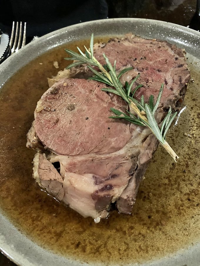 Prime rib that makes vegetarians question their life choices. That rosemary garnish isn't decoration&mdash;it's a victory flag planted on meat mountain.
