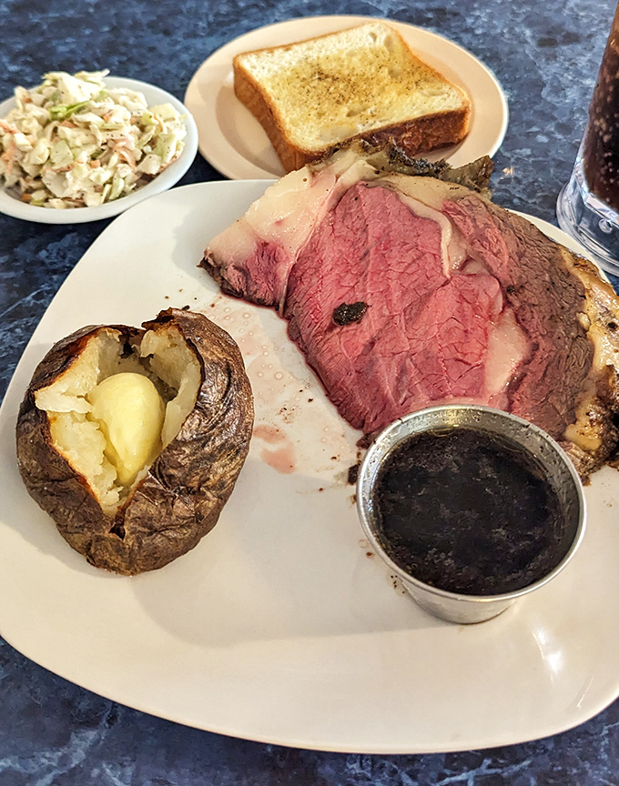 Behold the star of the show—prime rib so perfectly pink it should have its own Instagram account. That baked potato isn't just a side; it's a co-star.