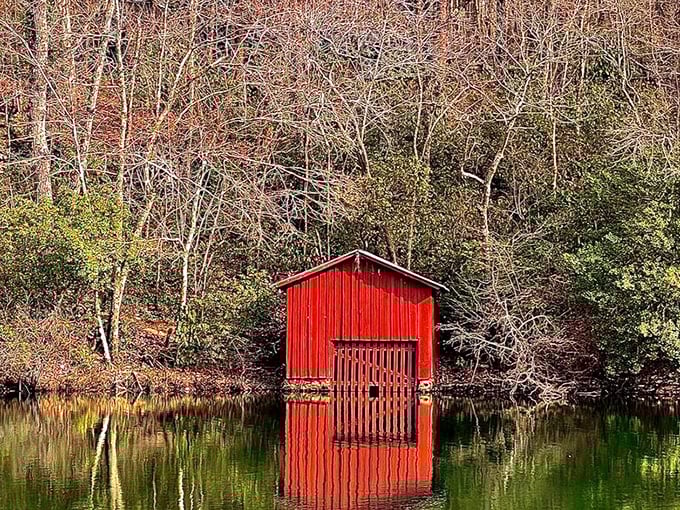 That little red boathouse reflecting in the still water is giving serious "painting come to life" vibes—Norman Rockwell would approve.