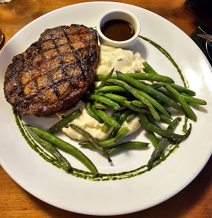 Behold the star of the show: a perfectly seared ribeye alongside vibrant green beans and creamy mashed potatoes. This plate practically whispers "treat yourself" in your ear.