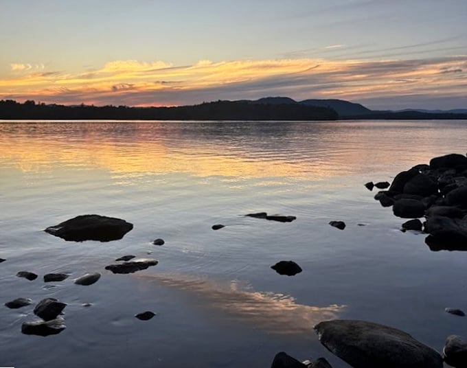 Twilight transforms Umbagog into liquid gold, where rocks emerge like ancient sentinels guarding New Hampshire's best-kept secret.