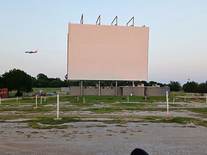 Twilight transforms the massive screen into a glowing beacon, with an airplane photobombing this perfect moment of Americana.