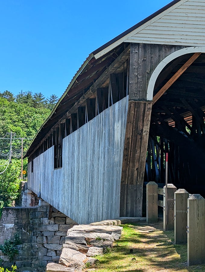 The bridge's weathered siding tells stories of countless New Hampshire seasons, its sturdy frame a testament to 19th-century craftsmanship.