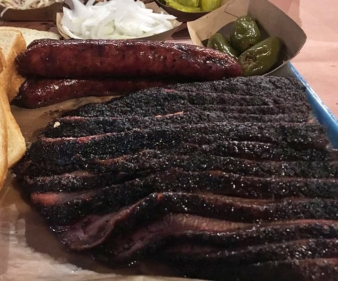 Behold the holy grail: brisket with a bark so perfect it should be in a museum, alongside sausage that snaps like the best punchline.