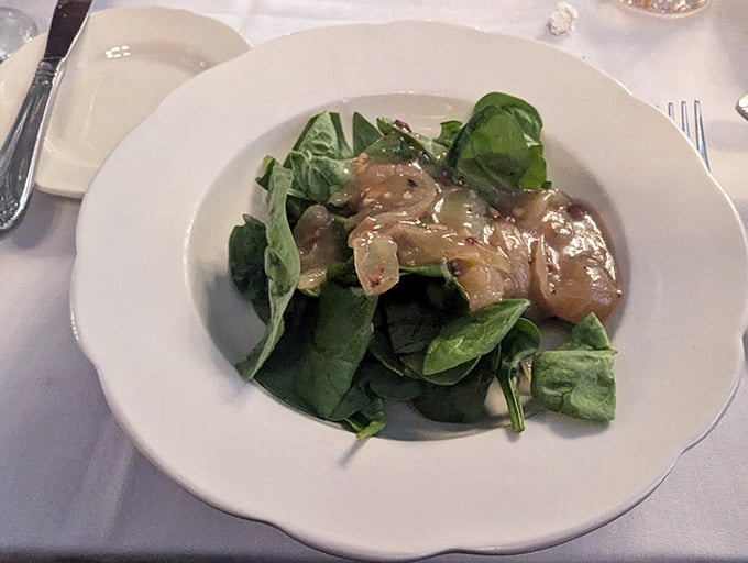 Behold the legendary spinach salad! Those glistening leaves aren't just wearing dressing&mdash;they're wearing decades of perfected flavor.