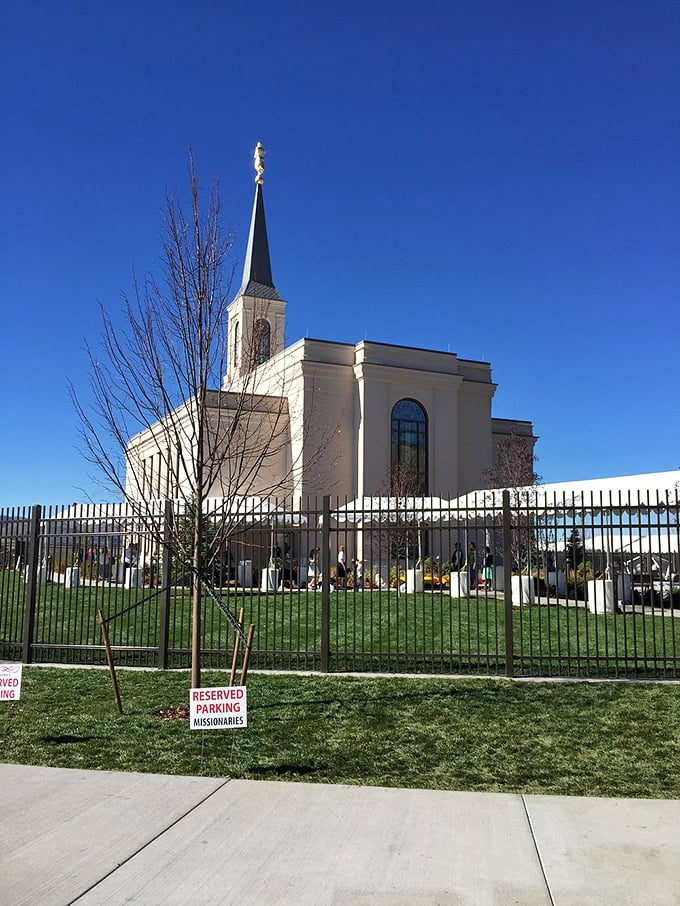 The Star Valley Wyoming Temple stands serenely against azure skies, its elegant spire reaching skyward like the surrounding mountains.