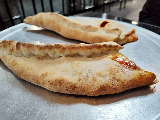 Behold the golden-brown beauties that have launched a thousand return trips&mdash;stromboli perfection on a simple white plate.