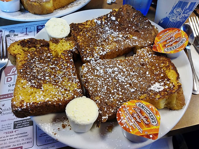 Behold the star attraction: French toast that's achieved the perfect balance of crispy exterior and custardy interior, dusted with powdered sugar like freshly fallen snow.
