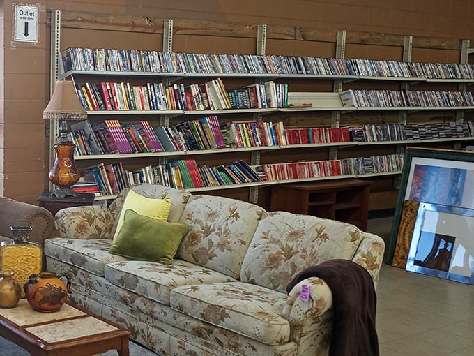 Behind this well-loved floral sofa lies a literary goldmine where paperback adventures and hardcover wisdom await new readers.