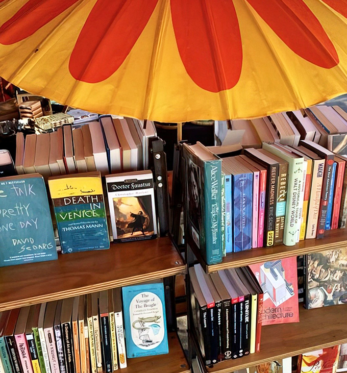 Literary treasures under a cheerful umbrella. Thomas Mann's "Death in Venice" sits alongside architecture tomes&mdash;intellectual browsing at its finest.