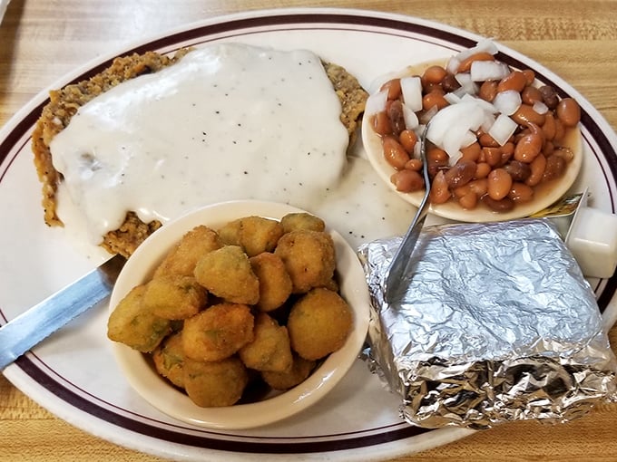 Country fried steak swimming in pepper-flecked gravy with a side of okra and baked beans. Southern comfort that hugs your soul from the inside.