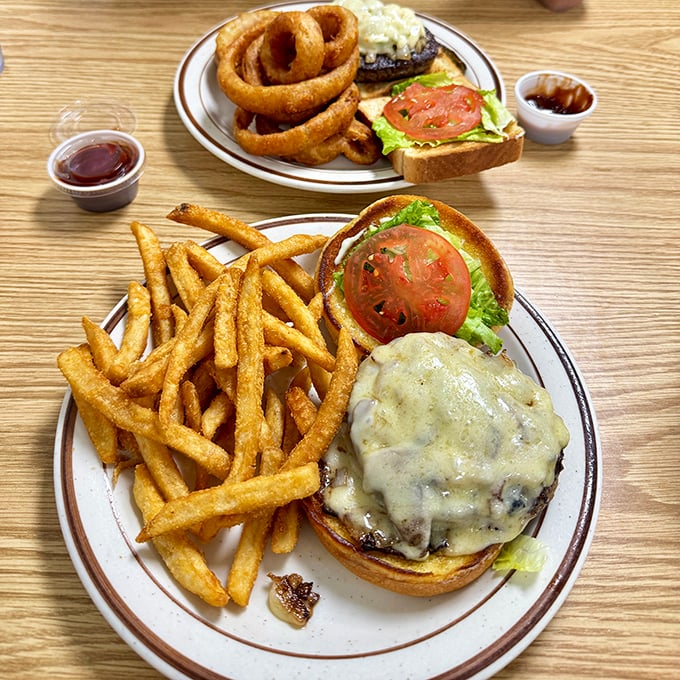 Classic diner perfection: a juicy cheeseburger with golden fries and those onion rings that make you temporarily forget about your cholesterol numbers.