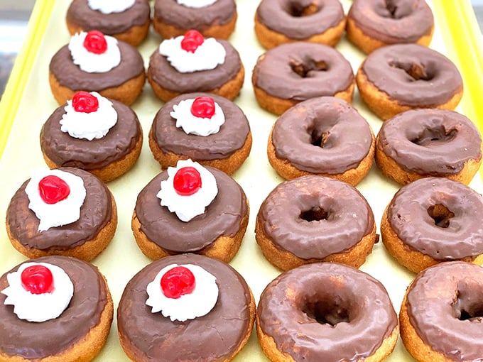 Chocolate lovers, rejoice! These perfectly glazed donuts with their cherry-topped centers are what breakfast dreams are made of.
