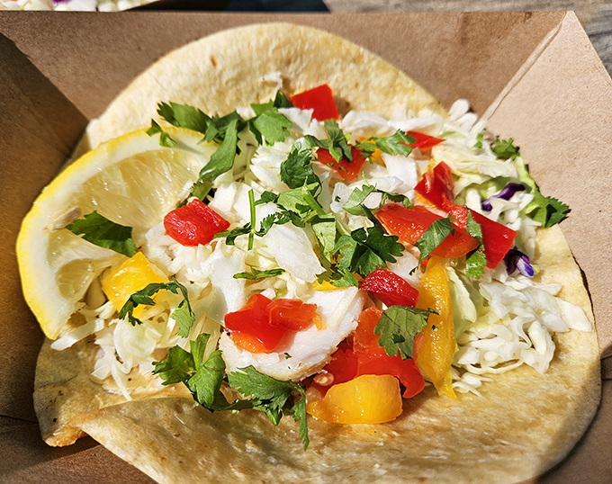 Behold the star of the show: fresh fish nestled in a flour tortilla, adorned with vibrant peppers and herbs. Worth every mile of the journey.