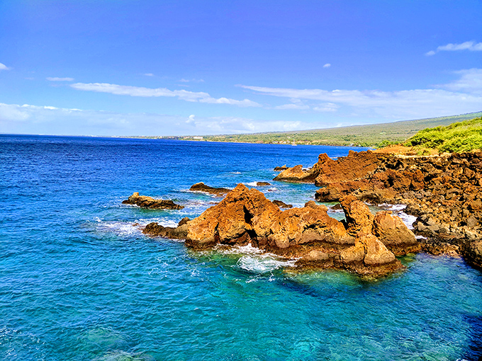 Ancient lava meets playful waves in a geological dance that's been performing for millennia. Nature's architecture at its finest.