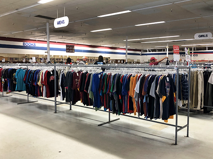 Men's clothing racks stretch like textile highways, where yesterday's fashion statements await their second chance to make first impressions.