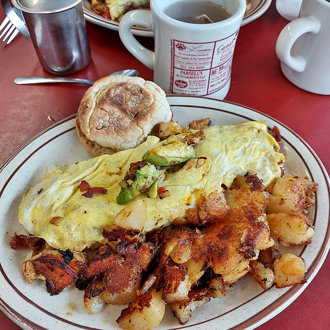 This isn't just an omelet&mdash;it's edible architecture with perfectly golden eggs embracing vibrant fillings, all beside home fries that deserve their own fan club.