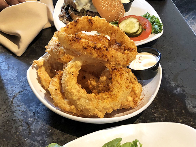Golden-brown onion rings stacked like delicious halos &ndash; crispy, light, and practically begging to be the supporting actor in your burger drama.