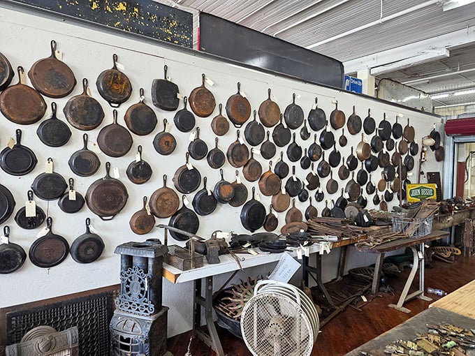 The wall of cast iron tells a story of American cooking history. Each seasoned pan represents thousands of meals and generations of family recipes.
