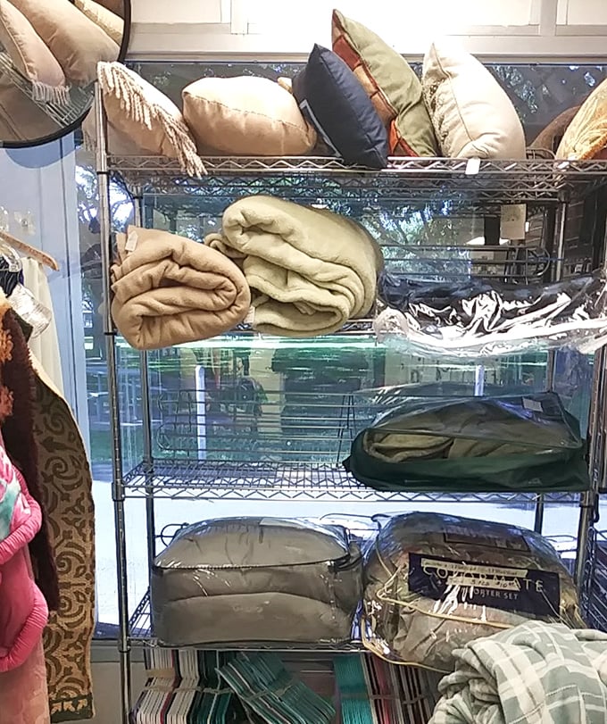 Cozy pillows and blankets stacked with care—because someone's "no longer sparking joy" might be your perfect nap companion.