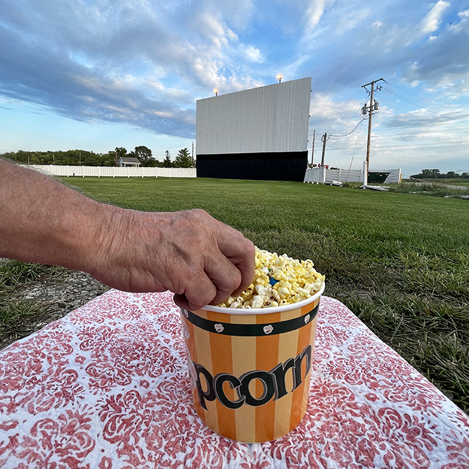 Buttery popcorn in a striped container, the essential drive-in companion. Some things taste better when eaten outdoors beneath a movie screen.