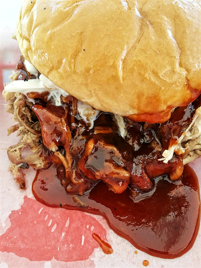 This pulled pork sandwich isn't just food; it's edible architecture &ndash; layers of smoky meat and sauce creating a delicious mess worth every napkin.