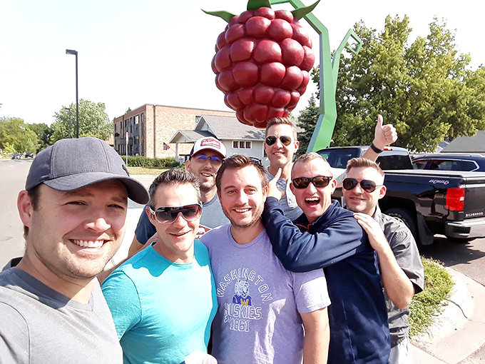 Nothing says "we found it!" like a group selfie with an oversized fruit. These visitors clearly understand roadside attraction protocol.