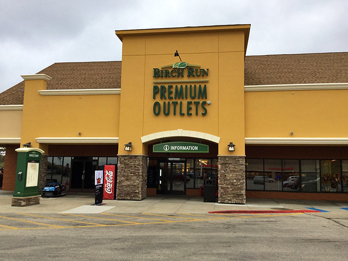 Birch Run's golden facade welcomes shoppers like a treasure chest promising designer deals beyond your wildest dreams.