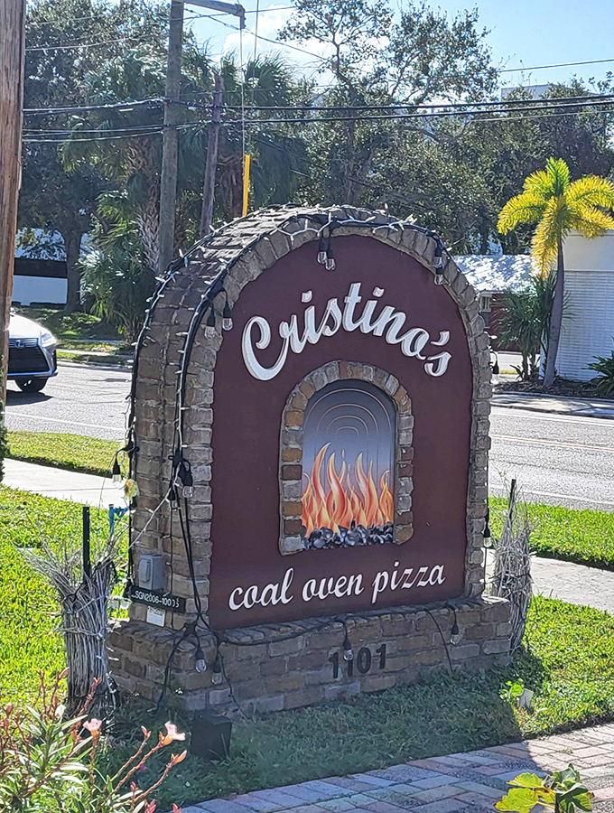Cristino's stone sign hints at the coal-fired magic happening inside. That flame illustration isn't just decoration&mdash;it's a taste preview.