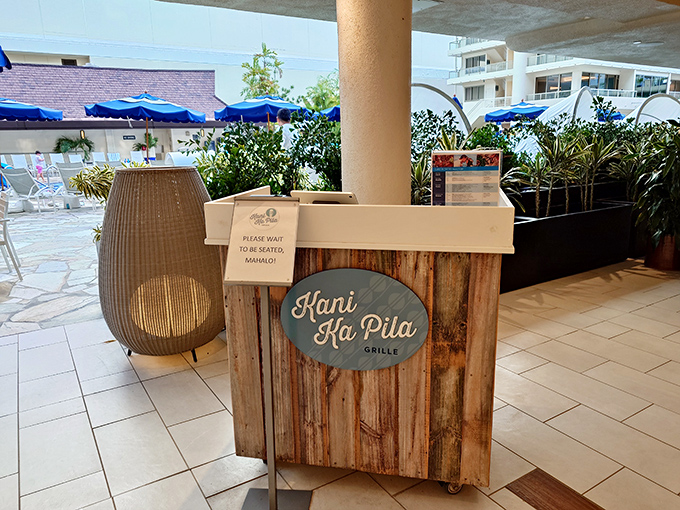 "Please wait to be seated, Mahalo!" The rustic charm of Kani Ka Pila's host stand is just the appetizer to the poolside feast for your senses.