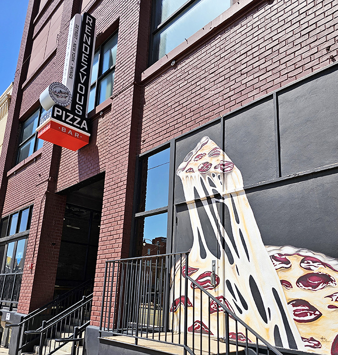 That stretchy-cheesy pizza mural isn't just art—it's Rendezvous Pizza's way of saying "Yes, we take our Detroit-style seriously."