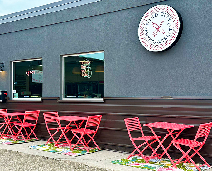 Wind City's sleek gray exterior with cheerful red seating creates the perfect stage for donut drama.
