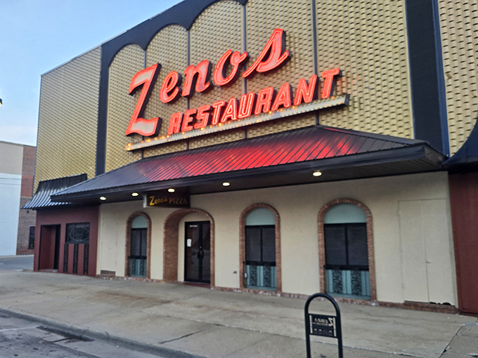 Zeno's bold sign dominates the streetscape like a pizza landmark. Some buildings house businesses; this one houses flavor memories.