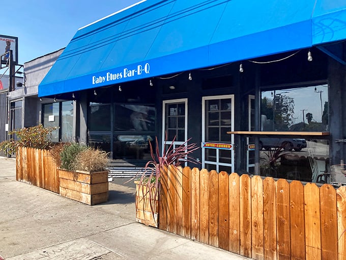 Where Southern BBQ traditions meet California beach vibes under a blue awning that's as inviting as the smells wafting from inside.
