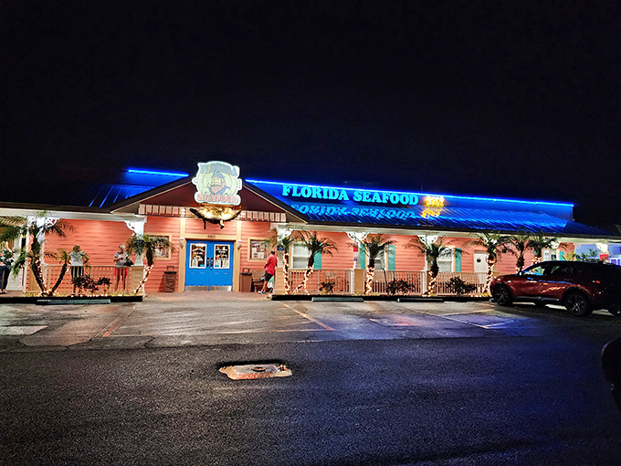 By night, Florida's Seafood transforms into a neon-lit beacon for crab cake enthusiasts. The pink building glows like a seafood lighthouse.