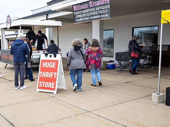 Bargain hunters gather outside Ultimate Treasures, drawn by the siren call of that "HUGE THRIFT STORE" sign.