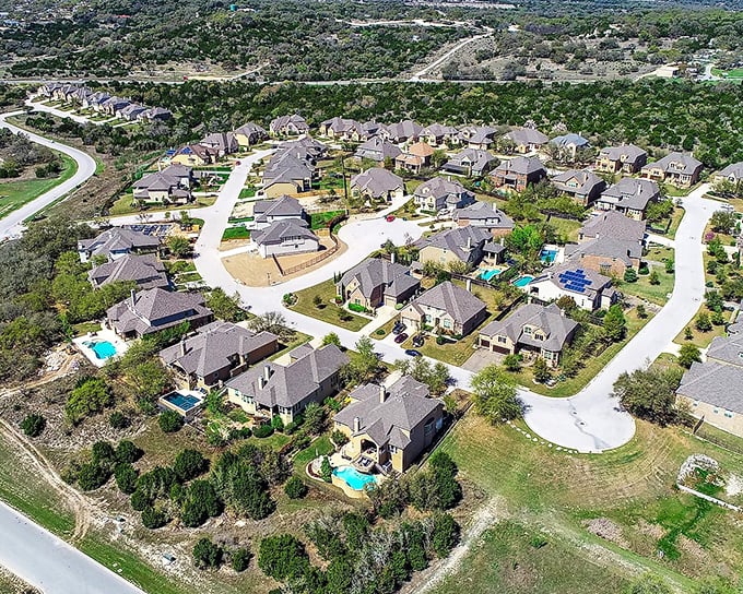  Like a real-life "Dynasty" set, this Hill Country haven showcases dream homes where every backyard pool sparkles like scattered sapphires.