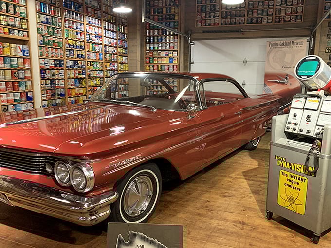 The 1960 Pontiac Ventura's copper-toned elegance is showcased against a backdrop of vintage oil cans, proving that automotive design once prioritized swagger over aerodynamics. 