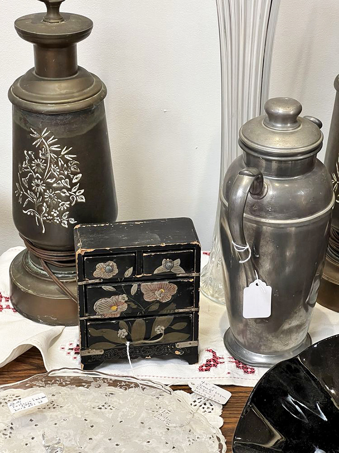 That ornate black jewelry box between vintage metal vessels tells stories from another era. Grandma would approve of this find.