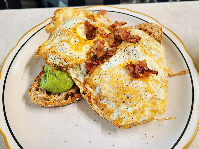 Avocado toast gets the diner treatment, crowned with eggs and bacon because balance is everything, right?